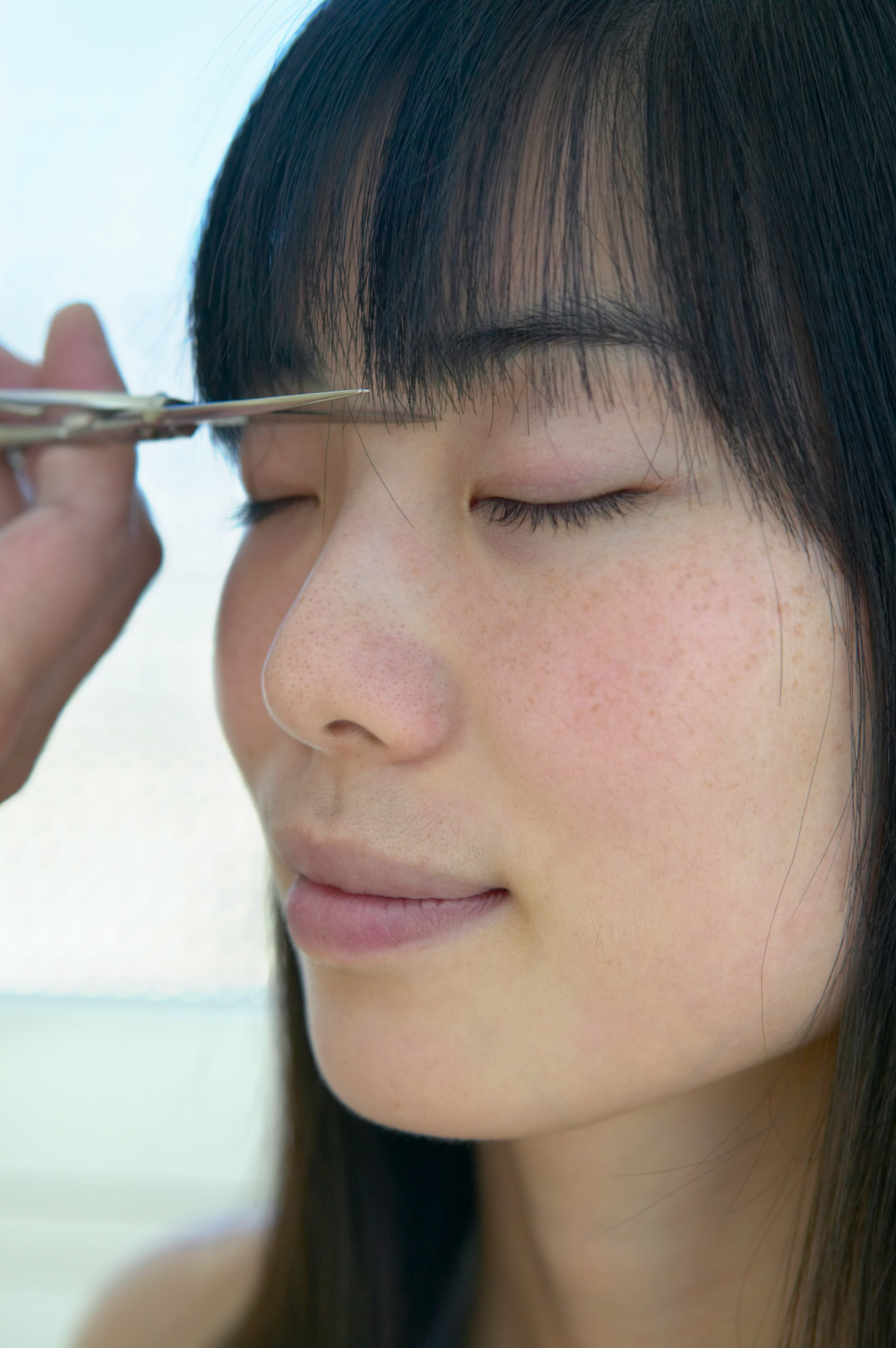 How To Trim Your Own Bangs At Home, According To Pro Hairstylists