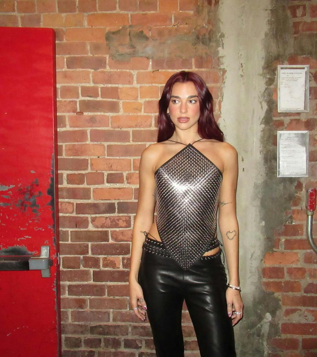 Dua Lipa's Y2K Look Combines A Halter Top, Grommets, & Whale Tail